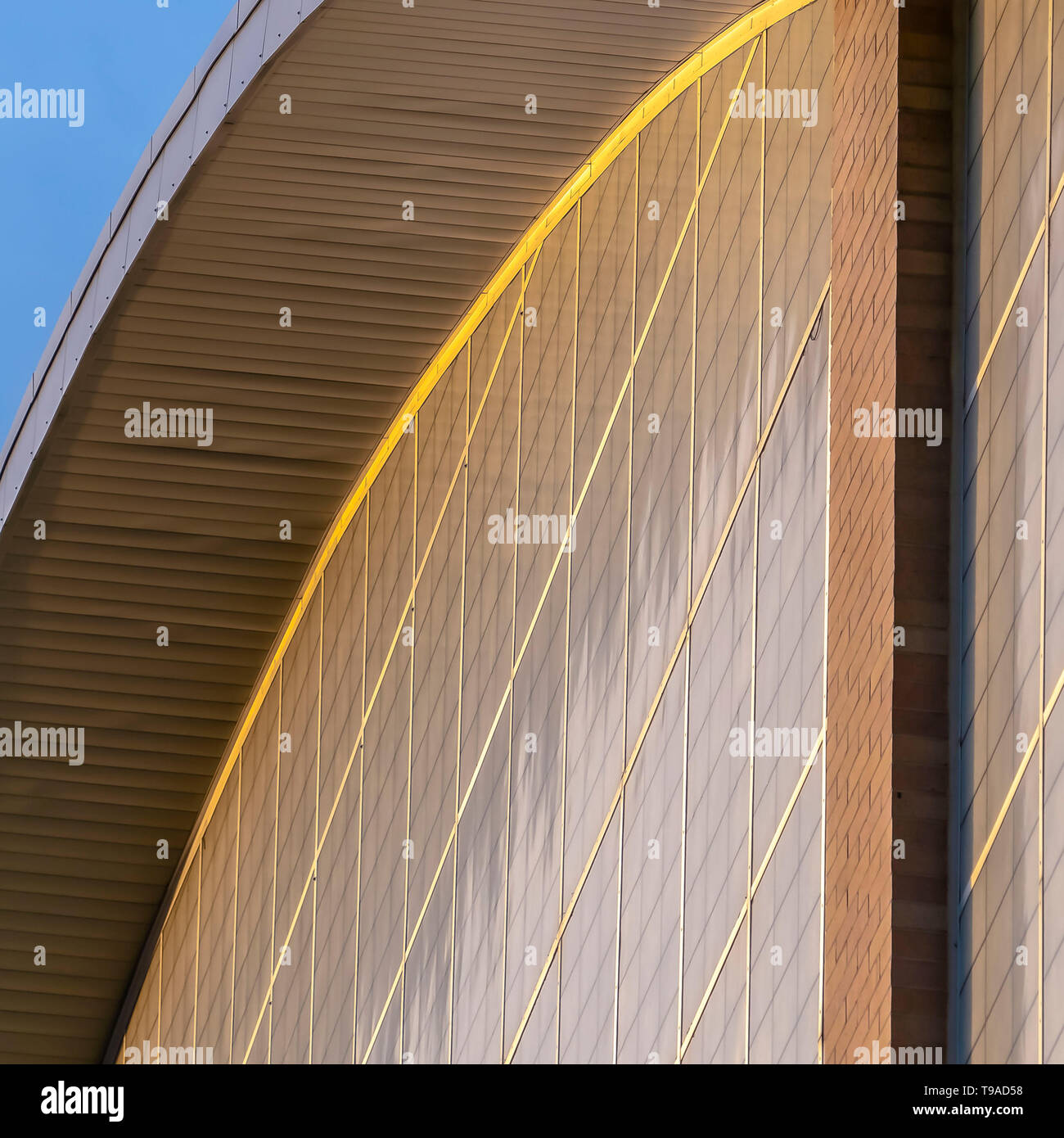 Square Exterior view of a building with a curved roof against blue sky ...