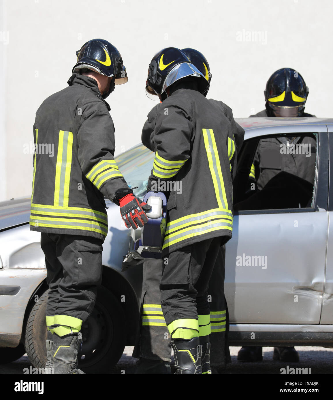 fire brigade team opens the door of the destroyed car with a large ...