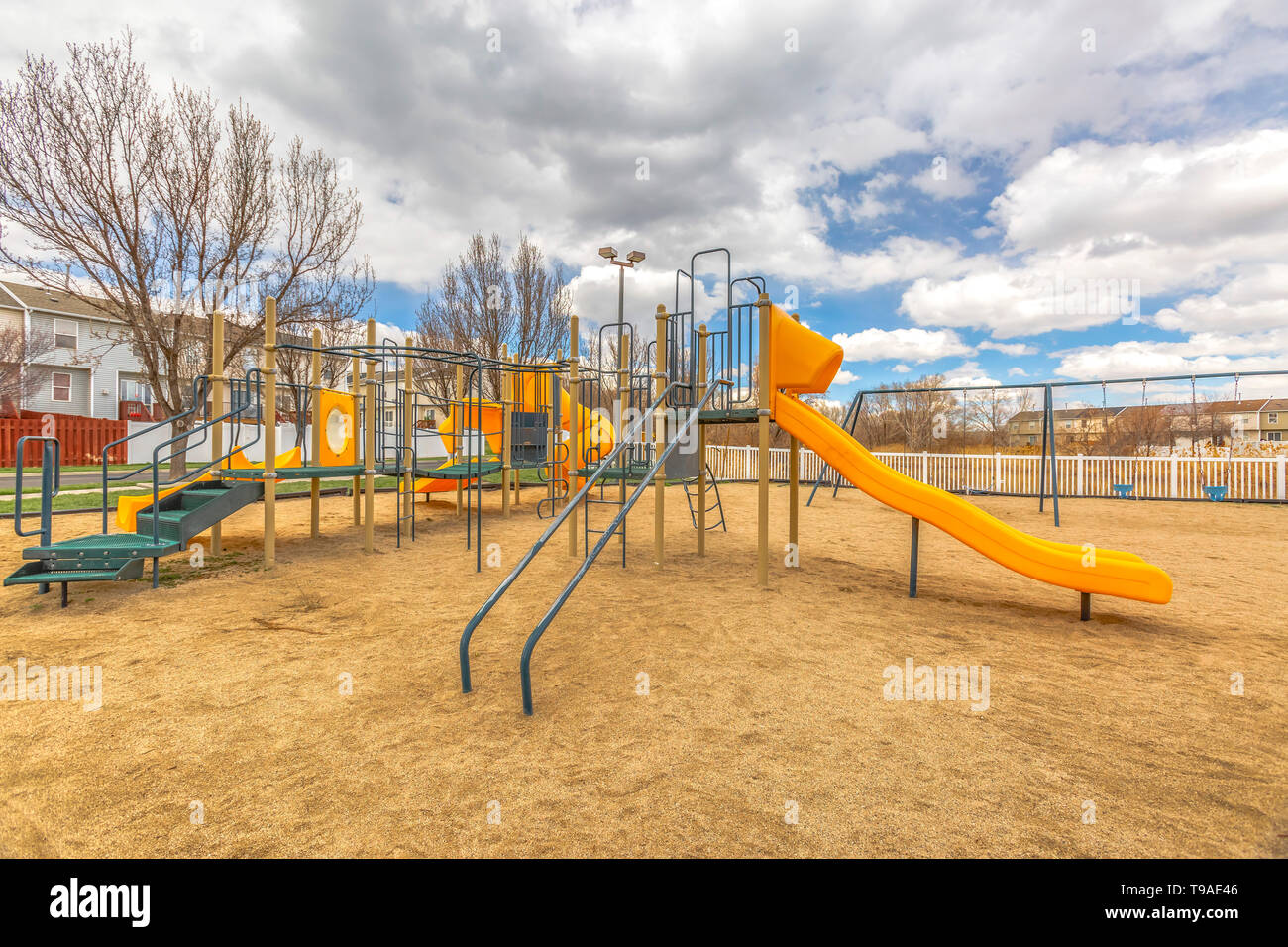 Playground with slides and swings under the blue sky filled with puffy ...