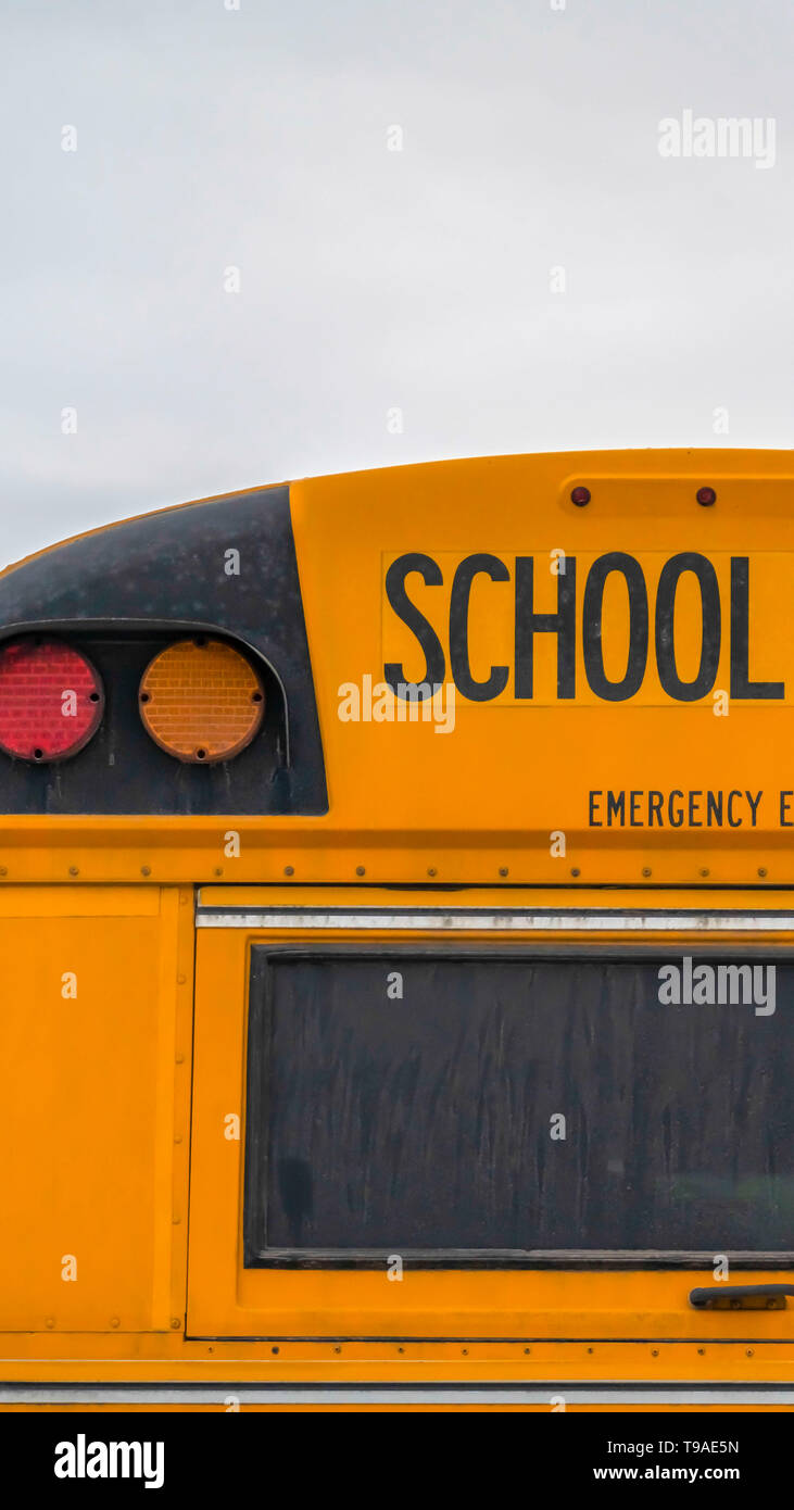 Clear Vertical Close up of the back side of a yellow school bus against ...