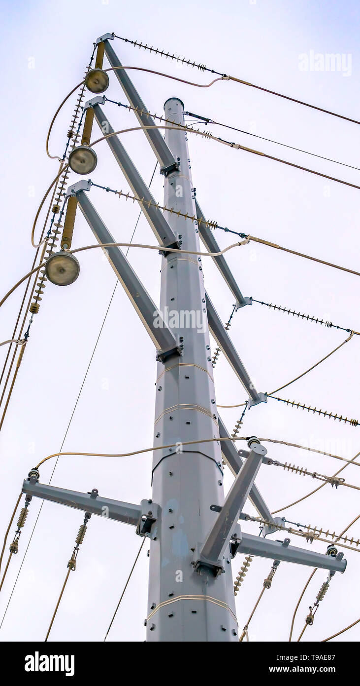 Clear Vertical Looking up at a towering metal post supporting overhead ...