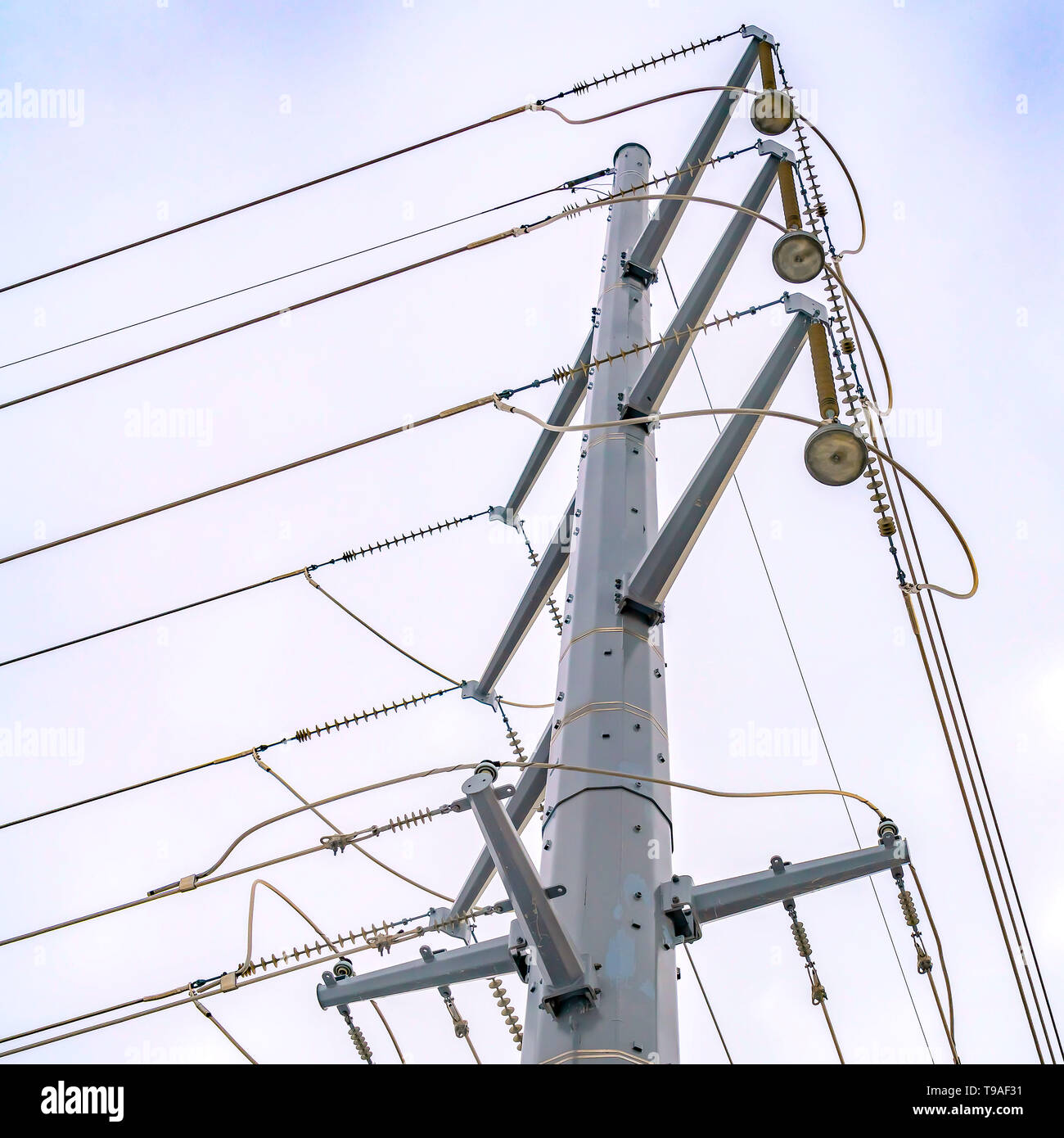 Square Looking up at a towering metal post supporting overhead power ...
