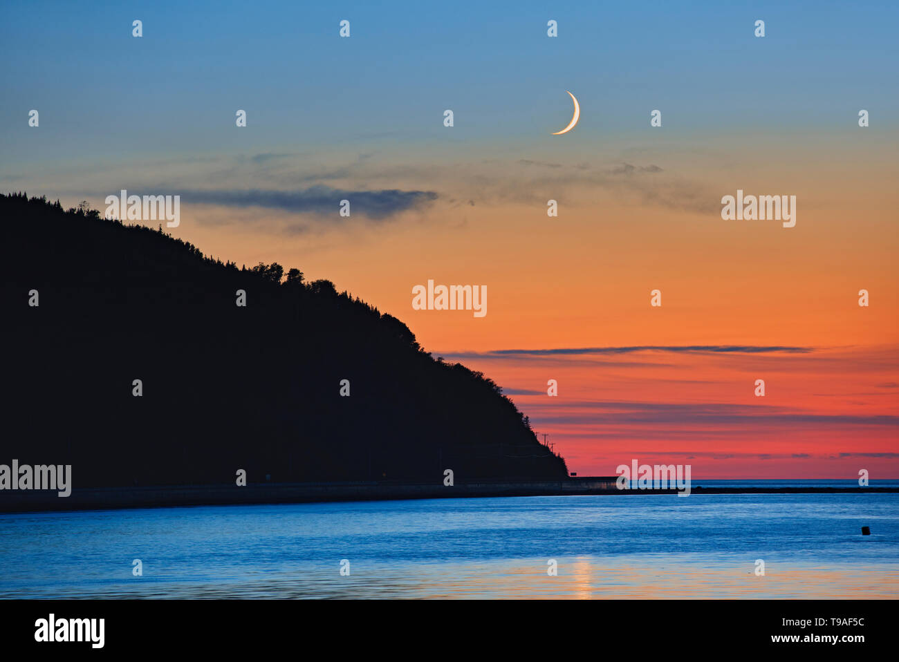 Shoreline along the Gulf of St. Lawrence at sunrise with crescent moon ...
