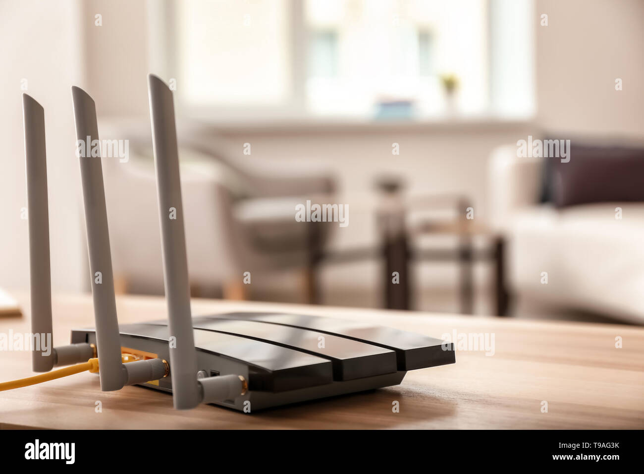 Modern wi-fi router on wooden table in room Stock Photo - Alamy