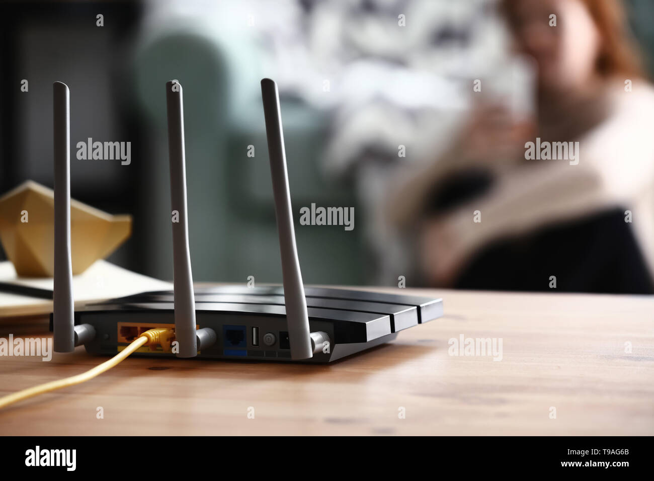 Modern wi-fi router on wooden table in room Stock Photo - Alamy