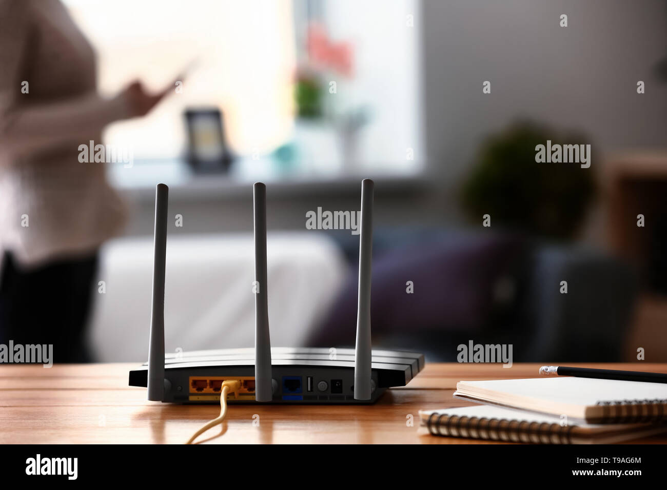 Modern wi-fi router on wooden table in room Stock Photo - Alamy