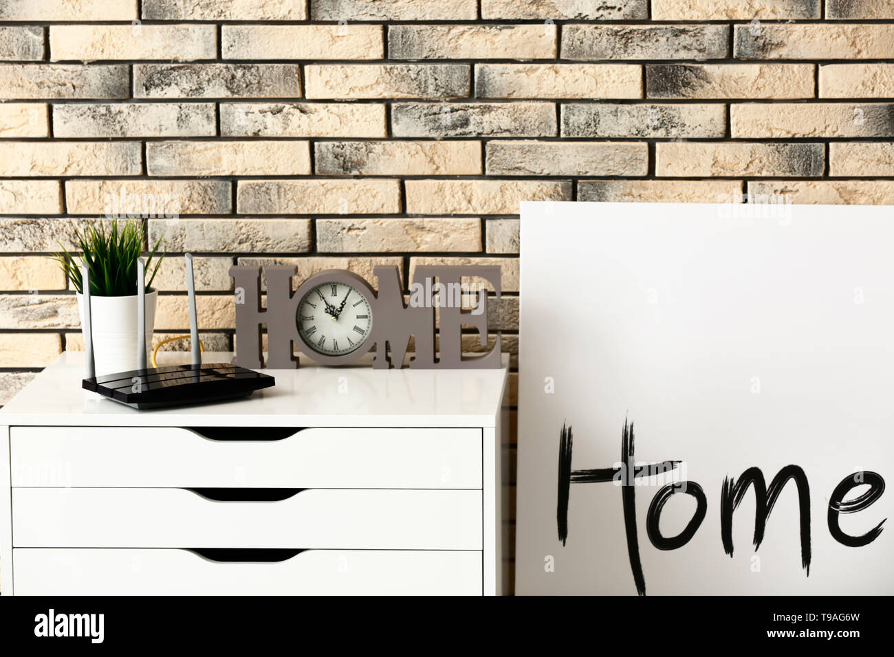 Modern wi-fi router on light commode near brick wall Stock Photo - Alamy