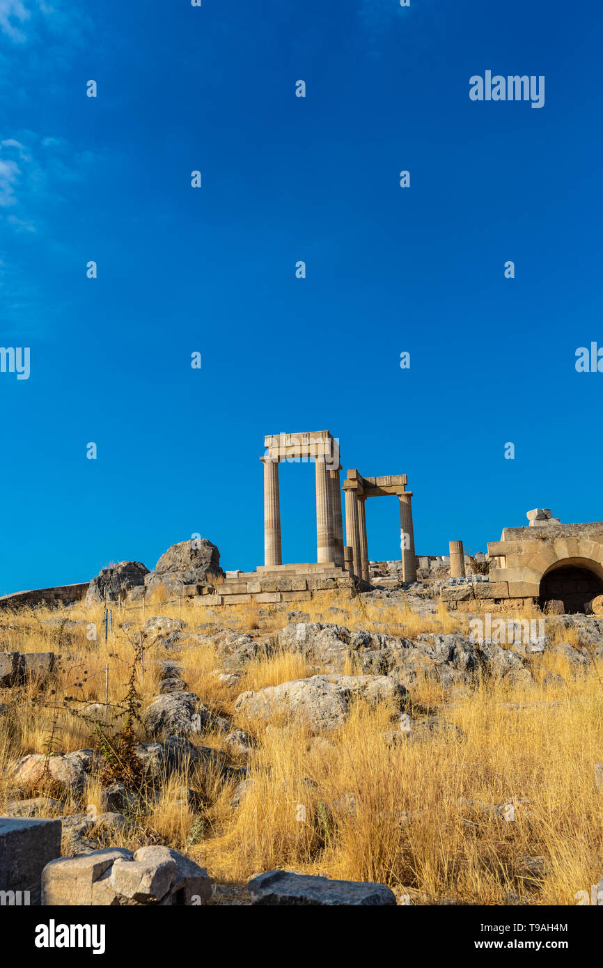 View from below of ancient stone pillars of the acropolis of Lindos ...
