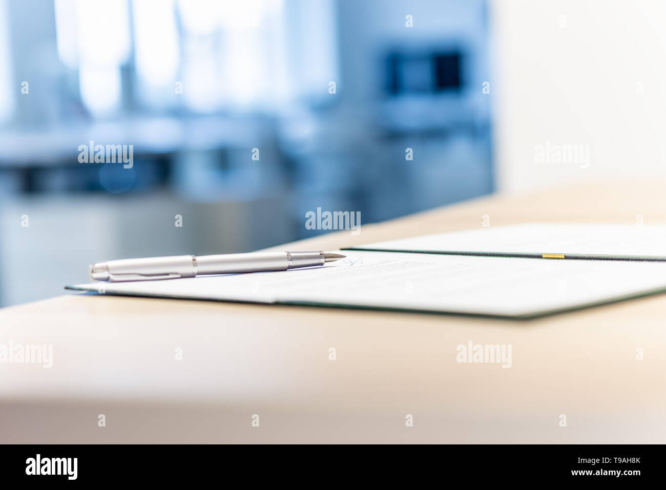 Business document in an open folder lying on an office desk with a pen ...
