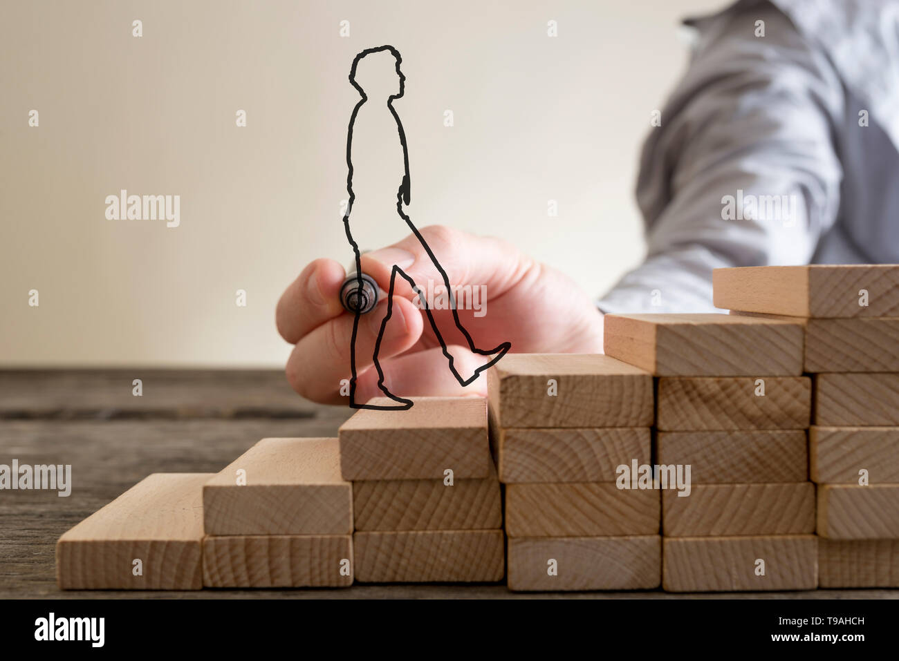 Man drawing the outline of a businessman climbing steps of stacked ...