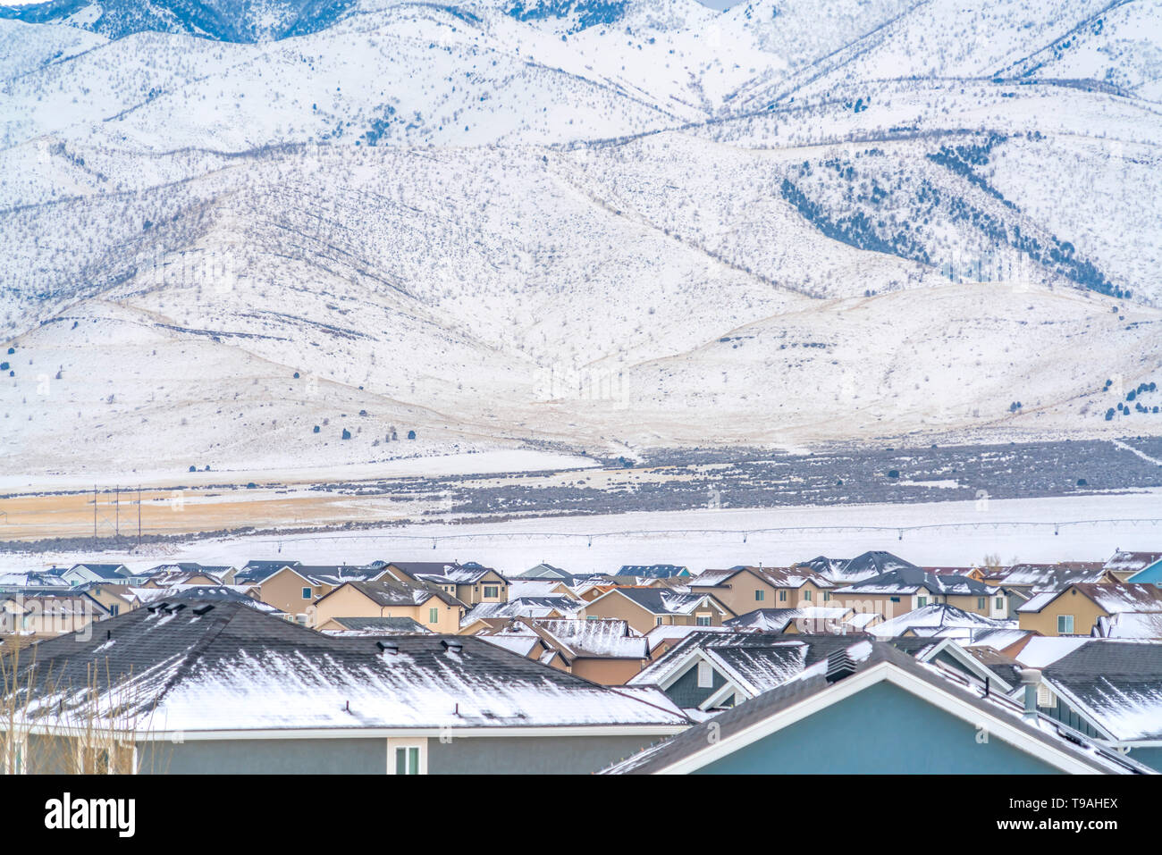 Scenic town near the base of a rugged mountain coated with snow in ...