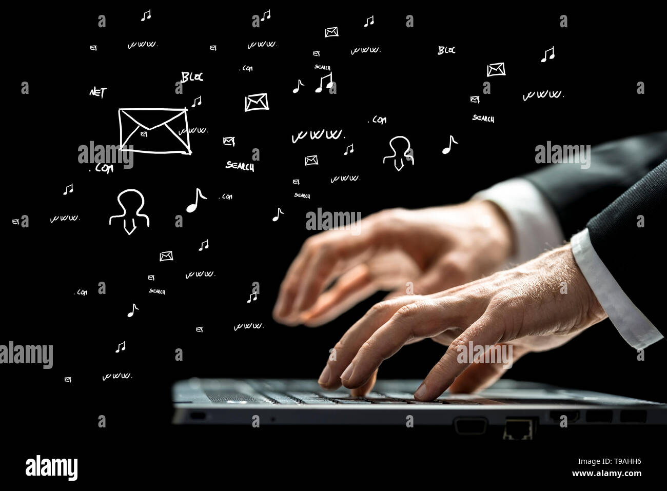 Businessman typing on a computer keyboard against a blackboard with ...