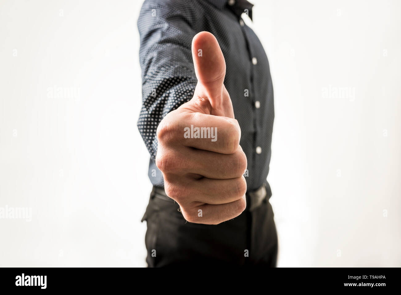 Closeup of businessman showing a thumbs up sign towards you. Over white ...