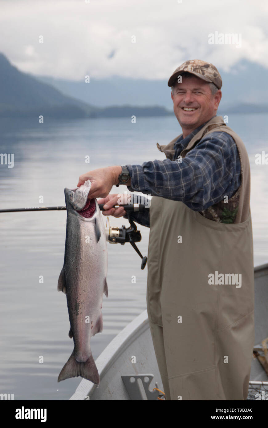 A salmon fisherman displays his fresh caught Silver (Coho) salmon while ...