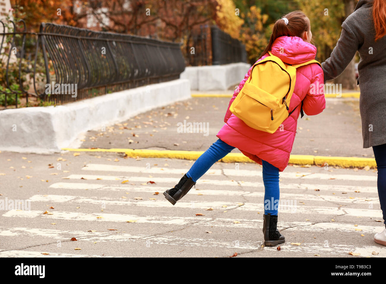 Cute little girl with mother crossing a road in city Stock Photo - Alamy