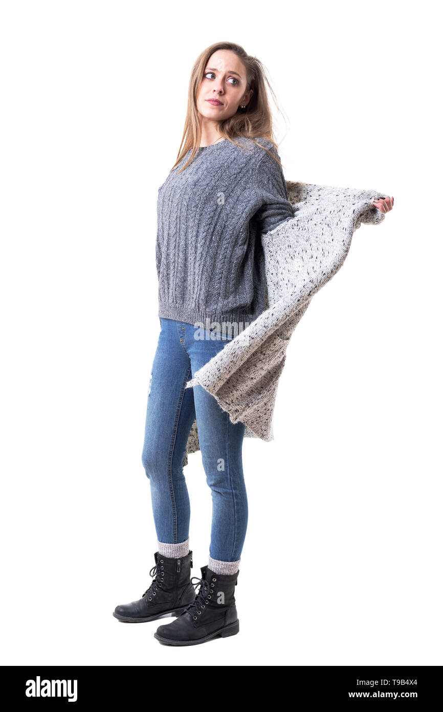 Side View Of Young Stylish Woman In Winter Clothes Undressing Taking