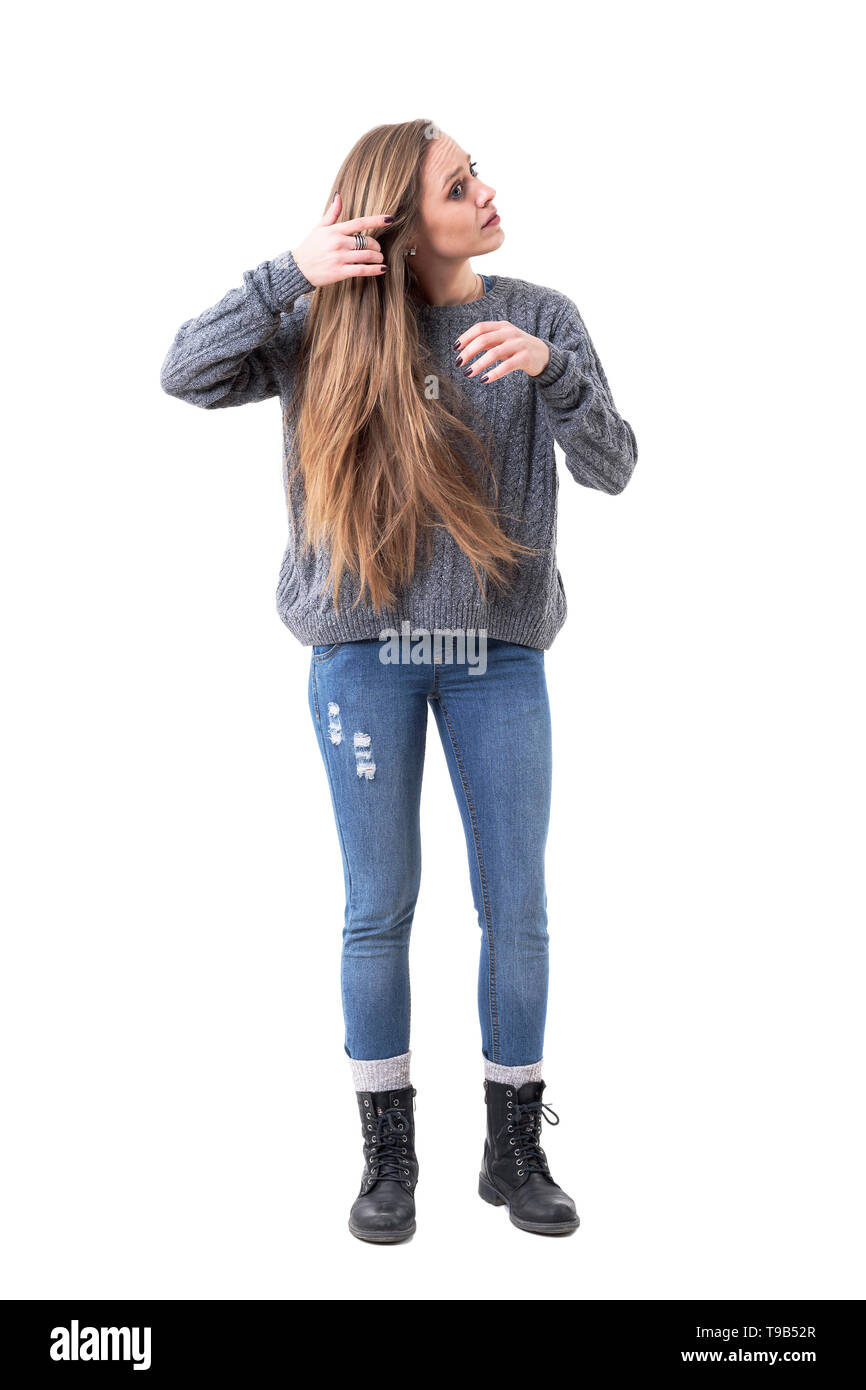 Young woman preening and touching long healthy hair looking away. Full ...