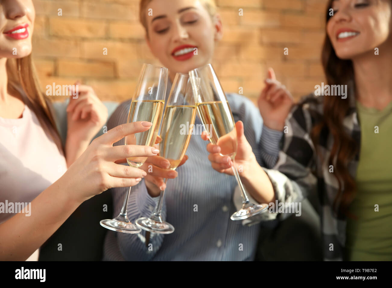 Beautiful young women drinking champagne at home Stock Photo - Alamy