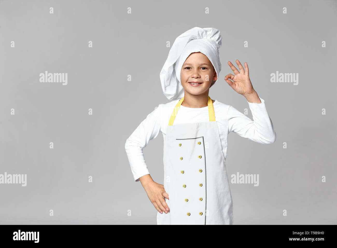 Cute little chef on grey background Stock Photo - Alamy