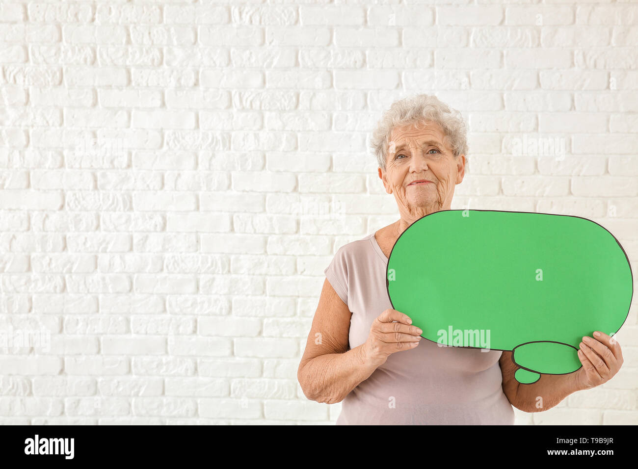 Senior woman with blank speech bubble on white background Stock Photo ...