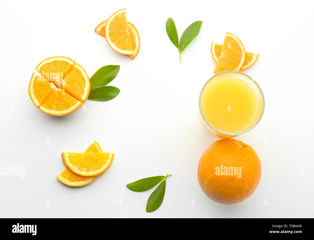 Frame made of sliced oranges and glass of juice on white background ...