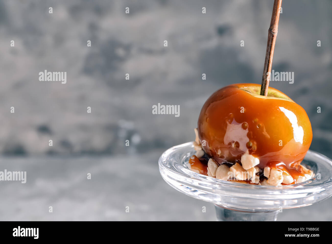 Delicious caramel apple with tree branch on glass stand Stock Photo - Alamy