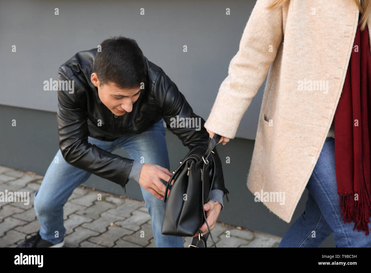 Male thief stealing bag from young woman outdoors Stock Photo - Alamy