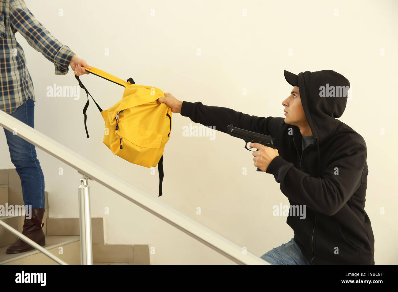 Male thief stealing bag from young woman in stairway Stock Photo - Alamy
