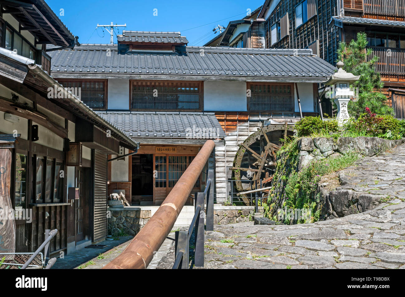 Steps, cobblestone street, water wheel and residences along the ...
