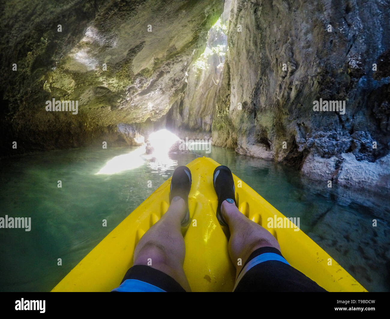 Kayaking through a cave in a beautiful tropical location with blue ...