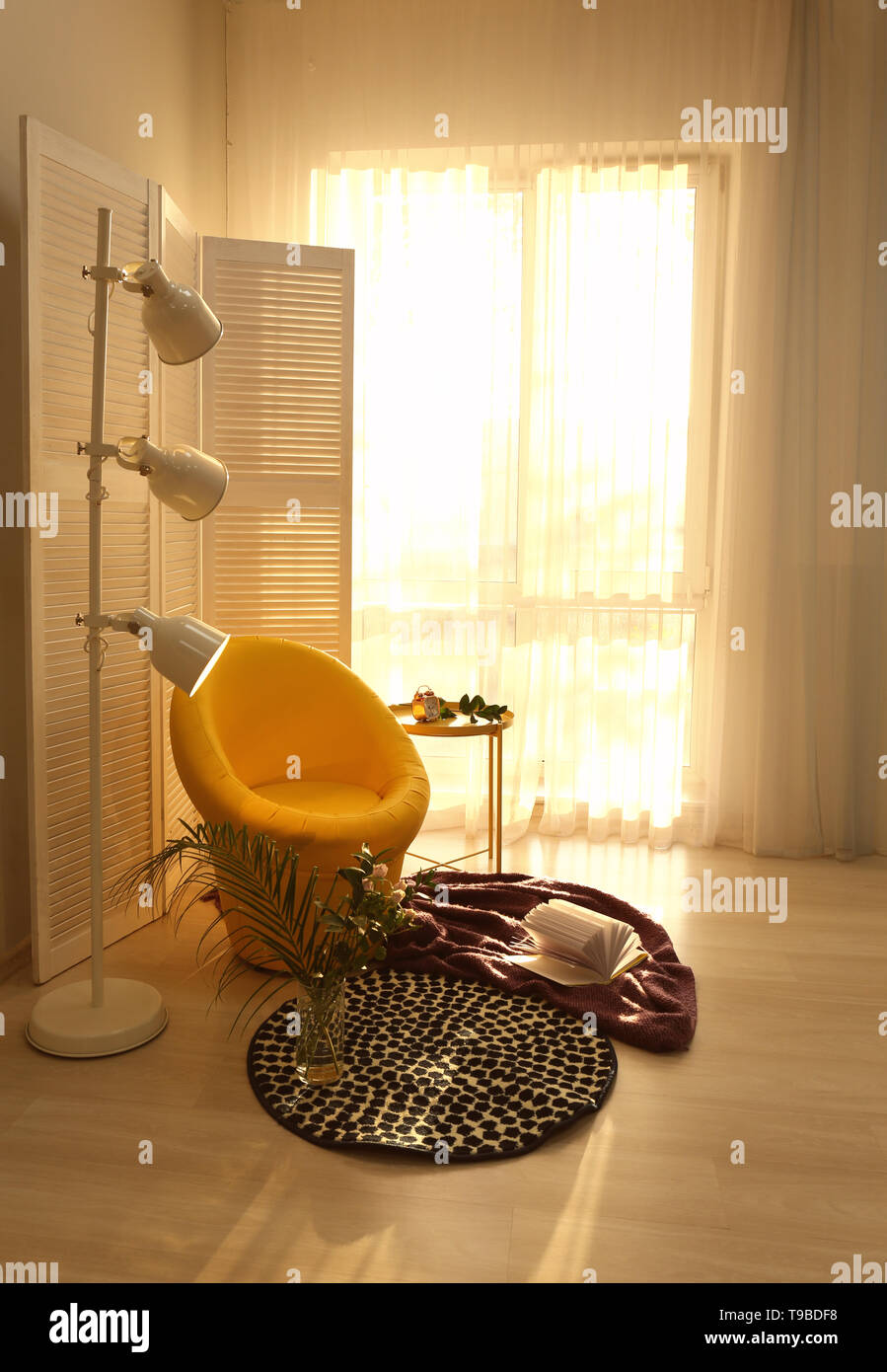 Cozy place for rest with armchair and soft plaid near window in room ...