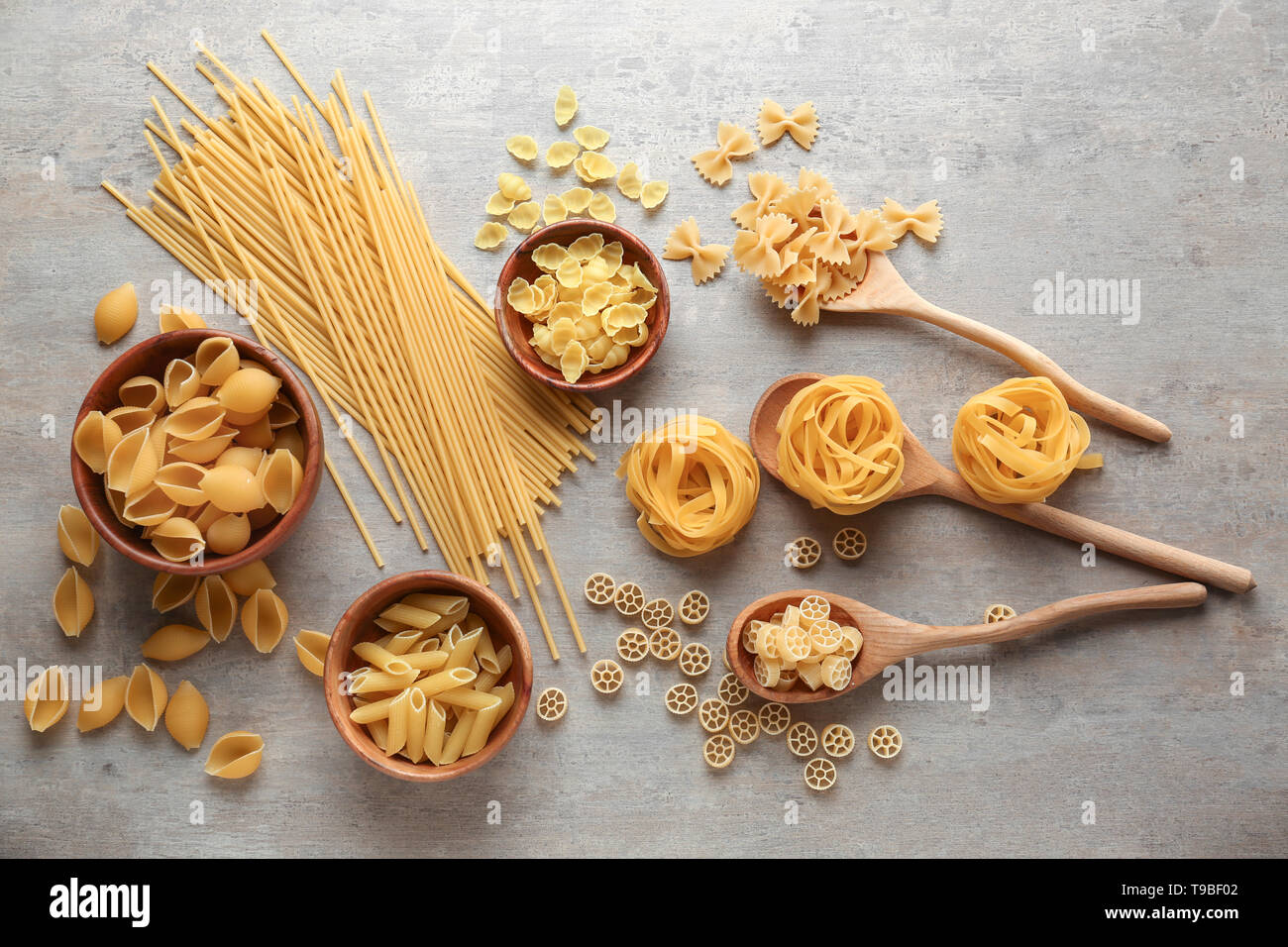 Different types of raw pasta on grey background Stock Photo - Alamy