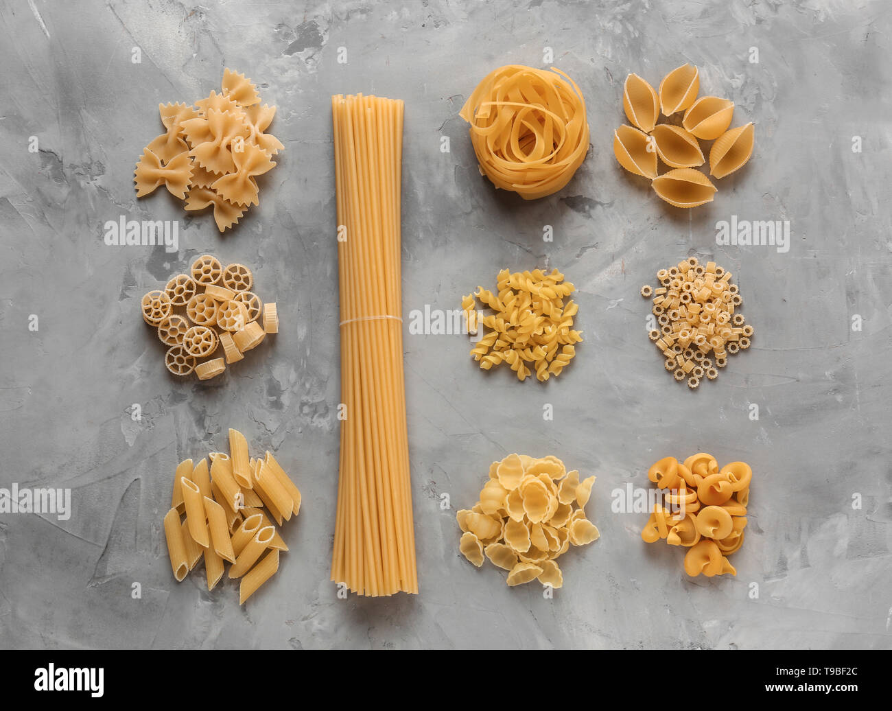 Different types of raw pasta on grey background Stock Photo - Alamy