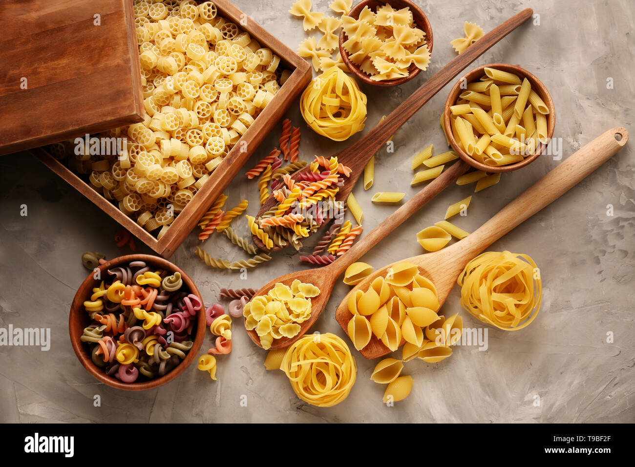 Different types of raw pasta on grey background Stock Photo - Alamy