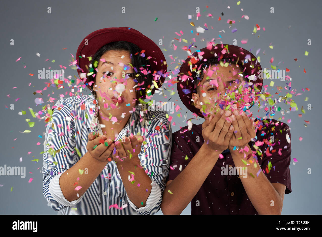 Party with confetti theme. People blowing colorful pieces of paper ...