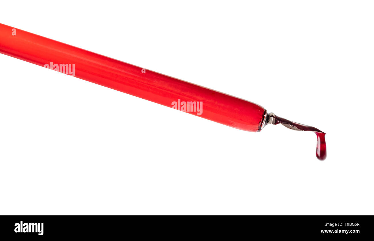 side view of red ink drop is hanging on the tip of nib pen cut out on ...