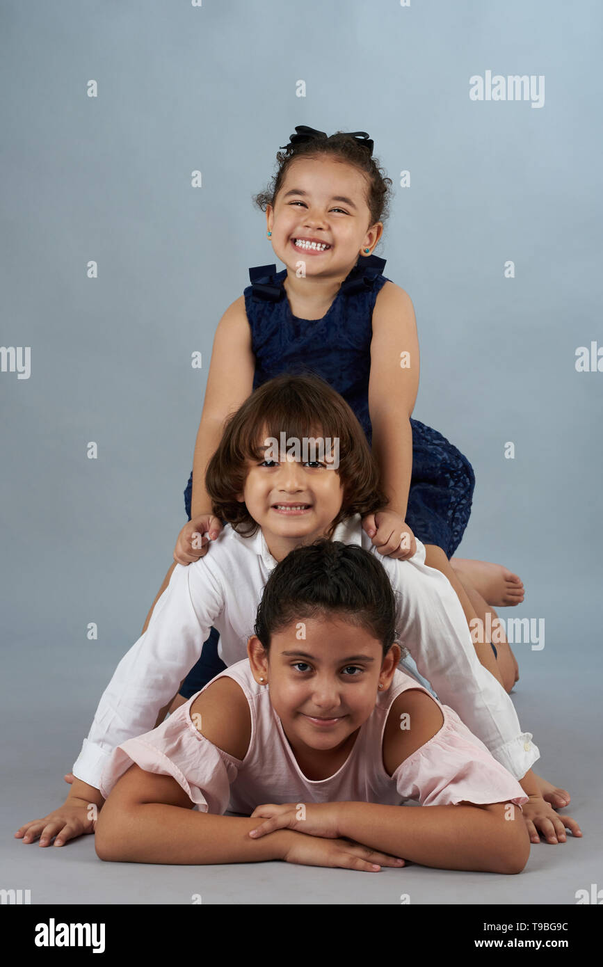 Happy group of kids in pyramid shape portrait isolated on gray studio ...