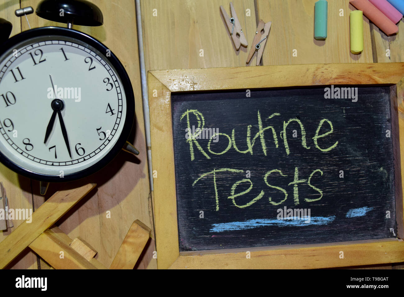 Routine Tests on phrase colorful handwritten on chalkboard and alarm ...