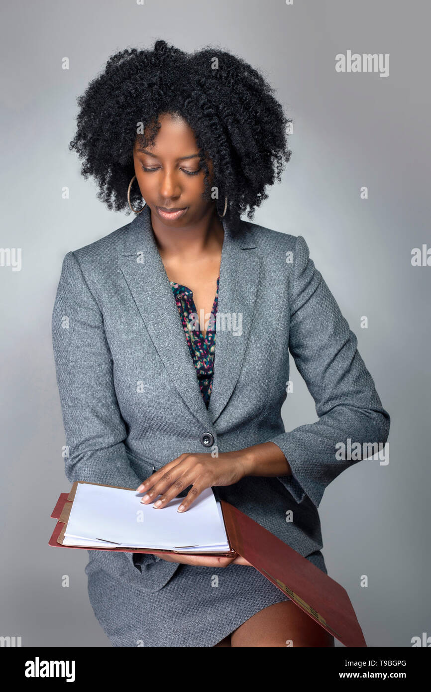 Black African American Businesswoman sitting and holding a folder of ...
