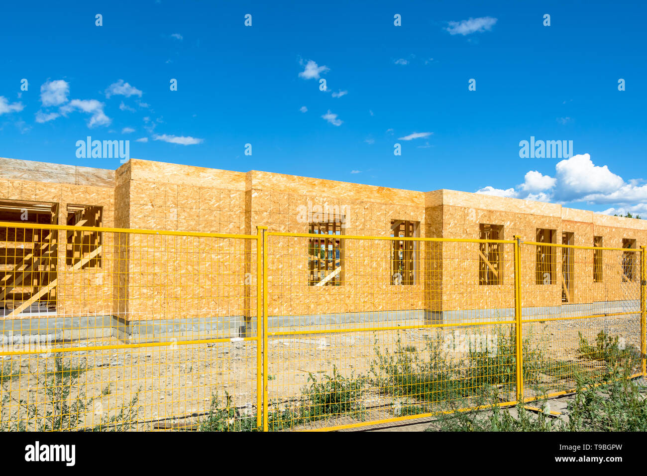 New residential building under construction with metal fence in front ...