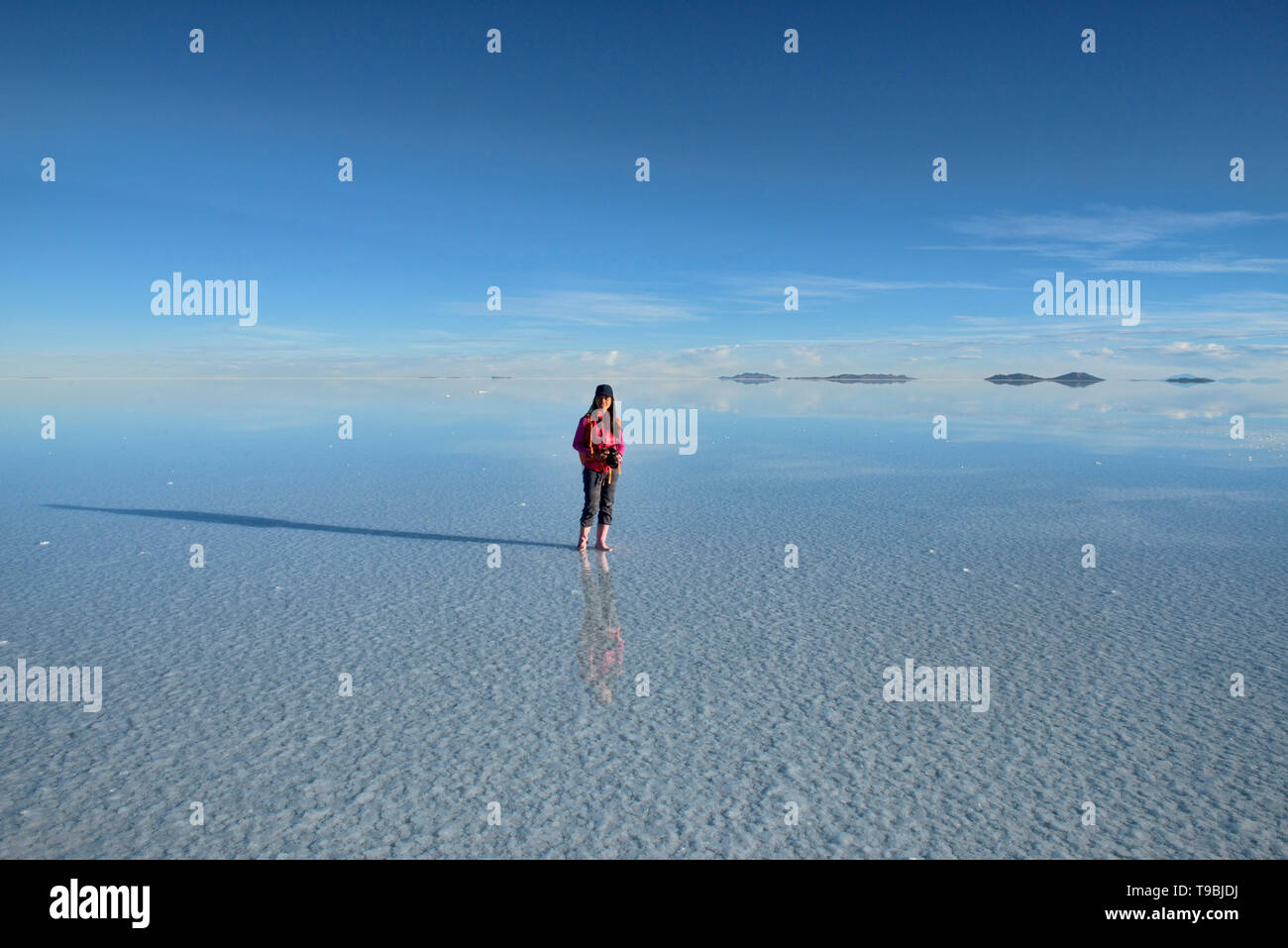 Tourist enjoying the world's largest mirror, the salt flats of the ...
