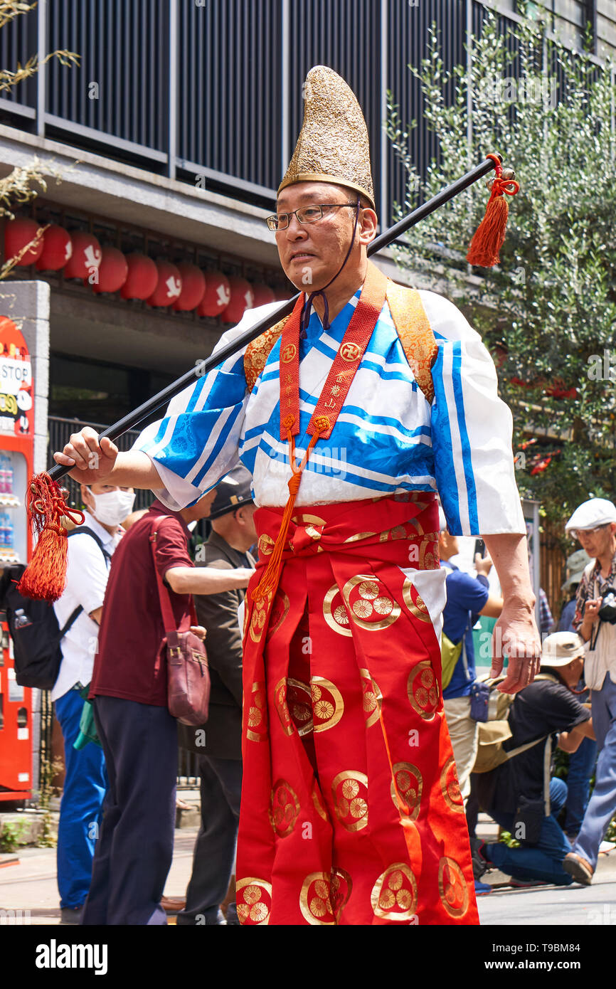 Japanese man dressed in vibrant red, gold, blue, and white traditional ...