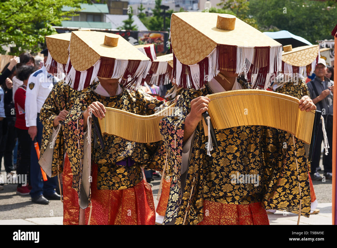 Japanese men in unique hats play the binzasara (a traditional wooden ...
