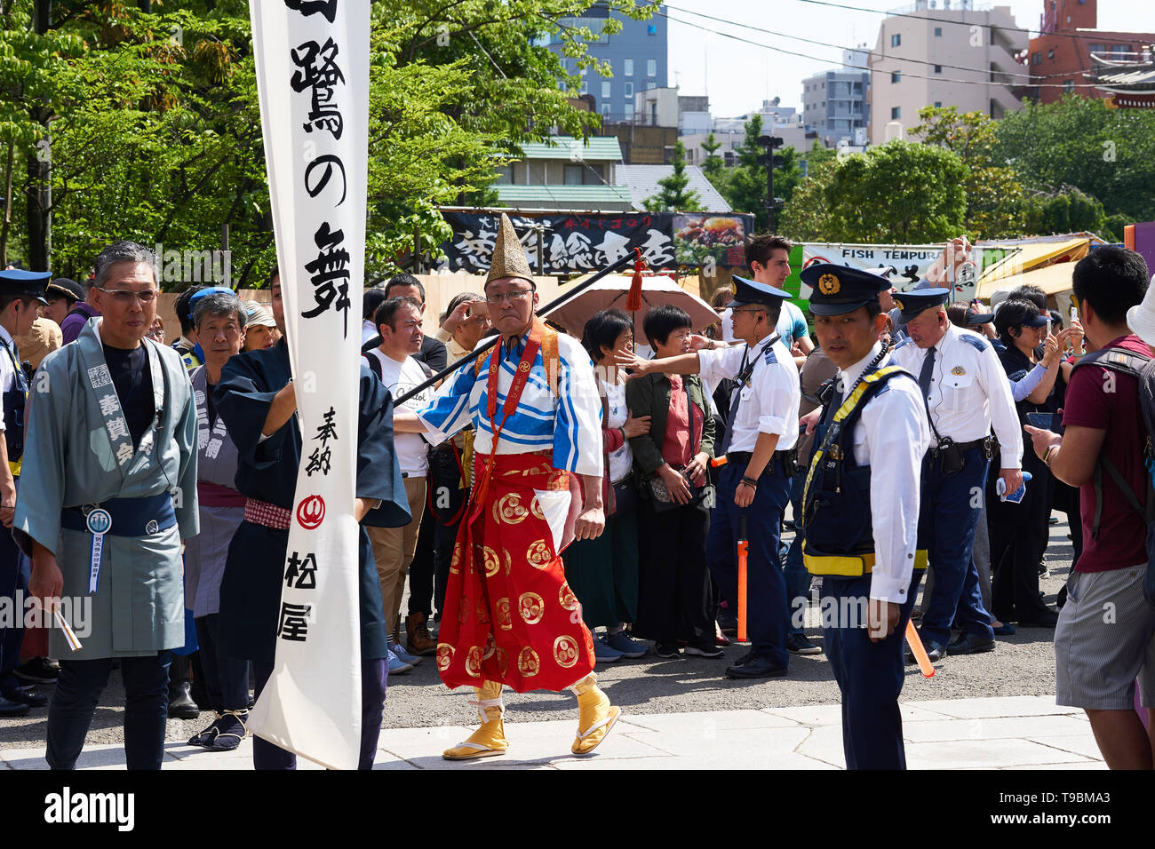 Japanese police manage the crowds at a procession during the Sanja ...