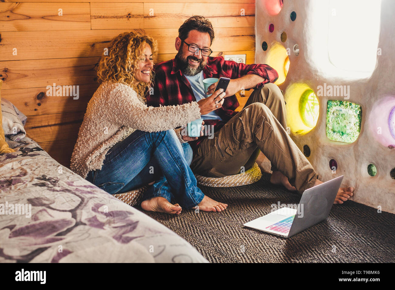 Happy couple at home in relationship and love use together technology ...