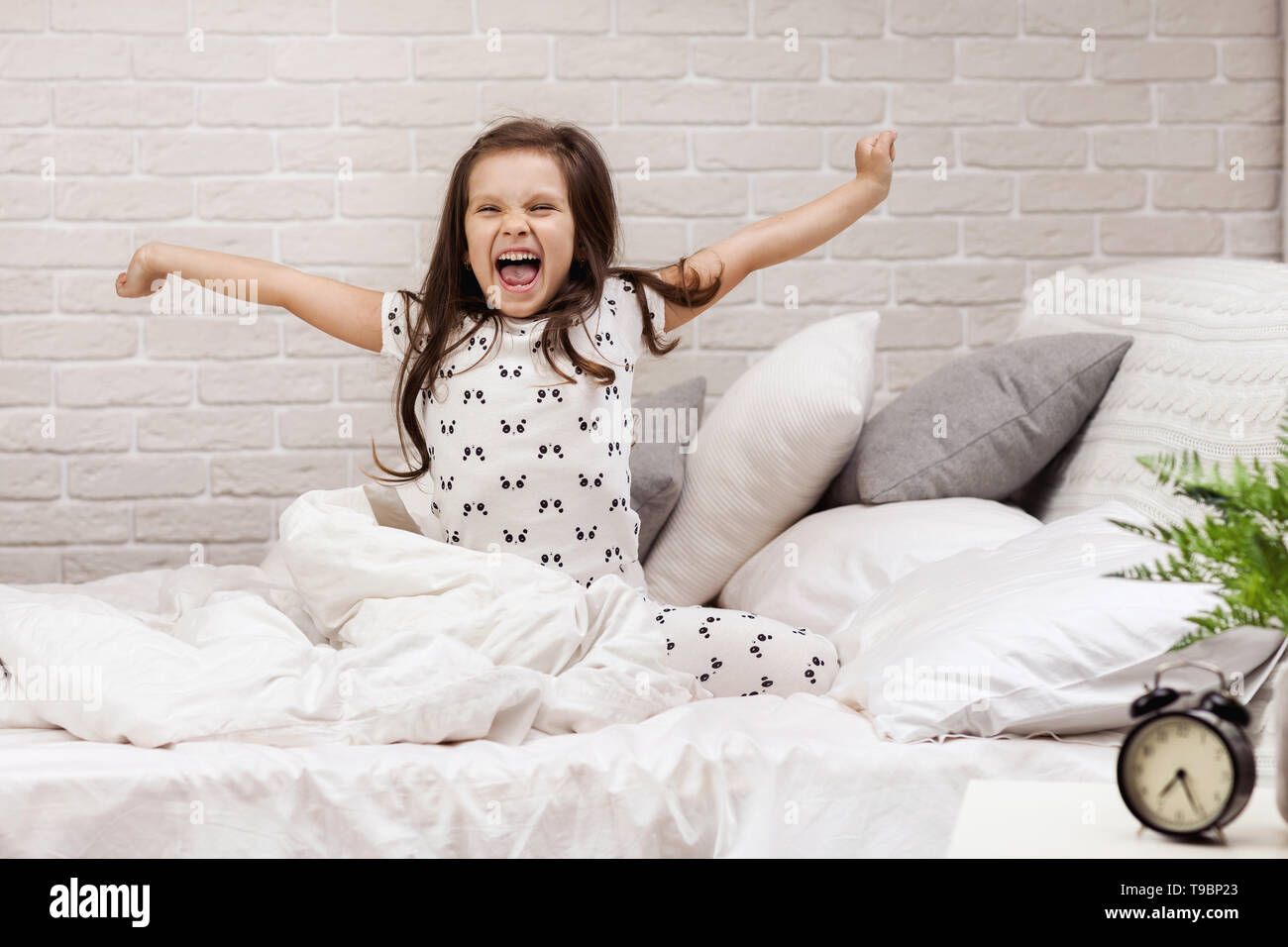 cute little child girl wakes up from sleep in bed in the morning Stock ...