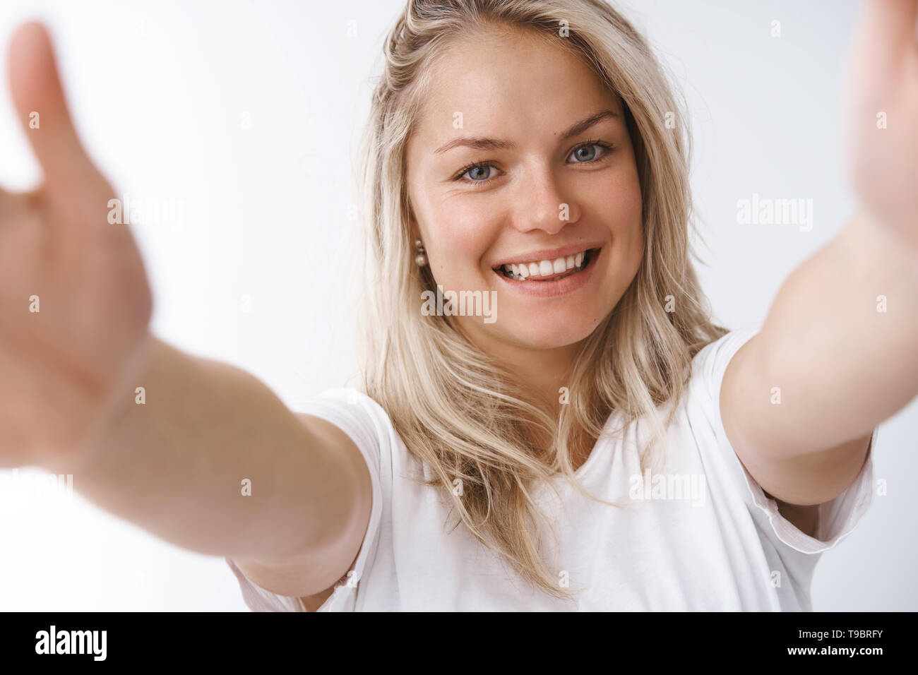 Girlfriend extends arms forward want hug. Studio shot carefree ...