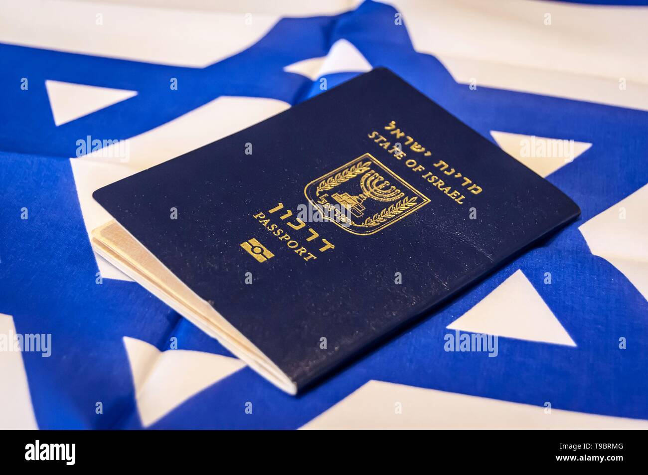 A blue passport of the State of Israel on Israeli flag on the ...