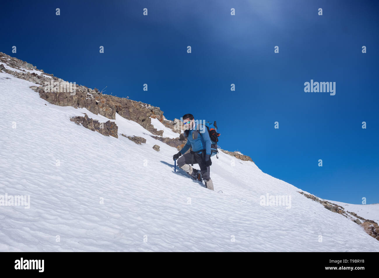 A climber walks across a filled snow mountain Stock Photo - Alamy