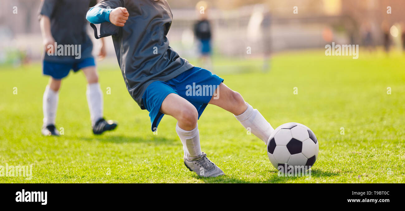 Young football soccer player kick ball on green grass sports venue ...